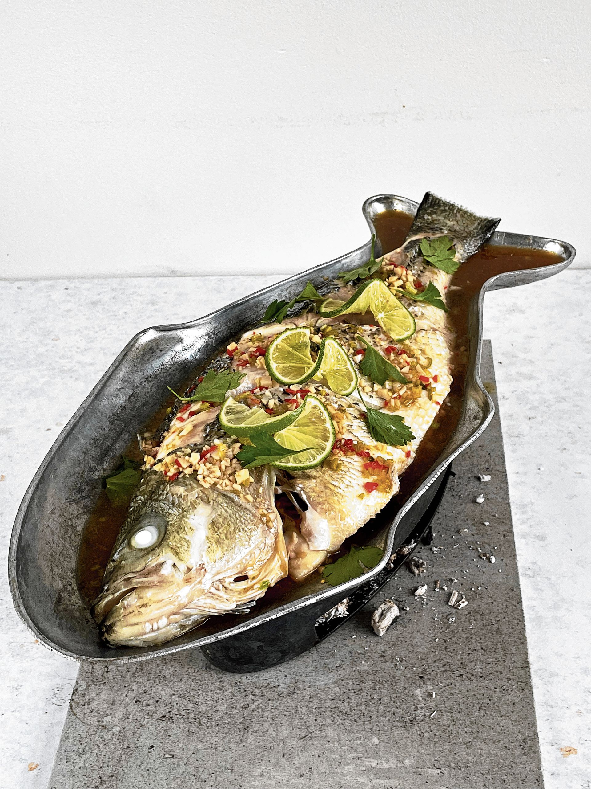 Een vis, drijvend in een intens geurige, limoenige, knoflokerige ...